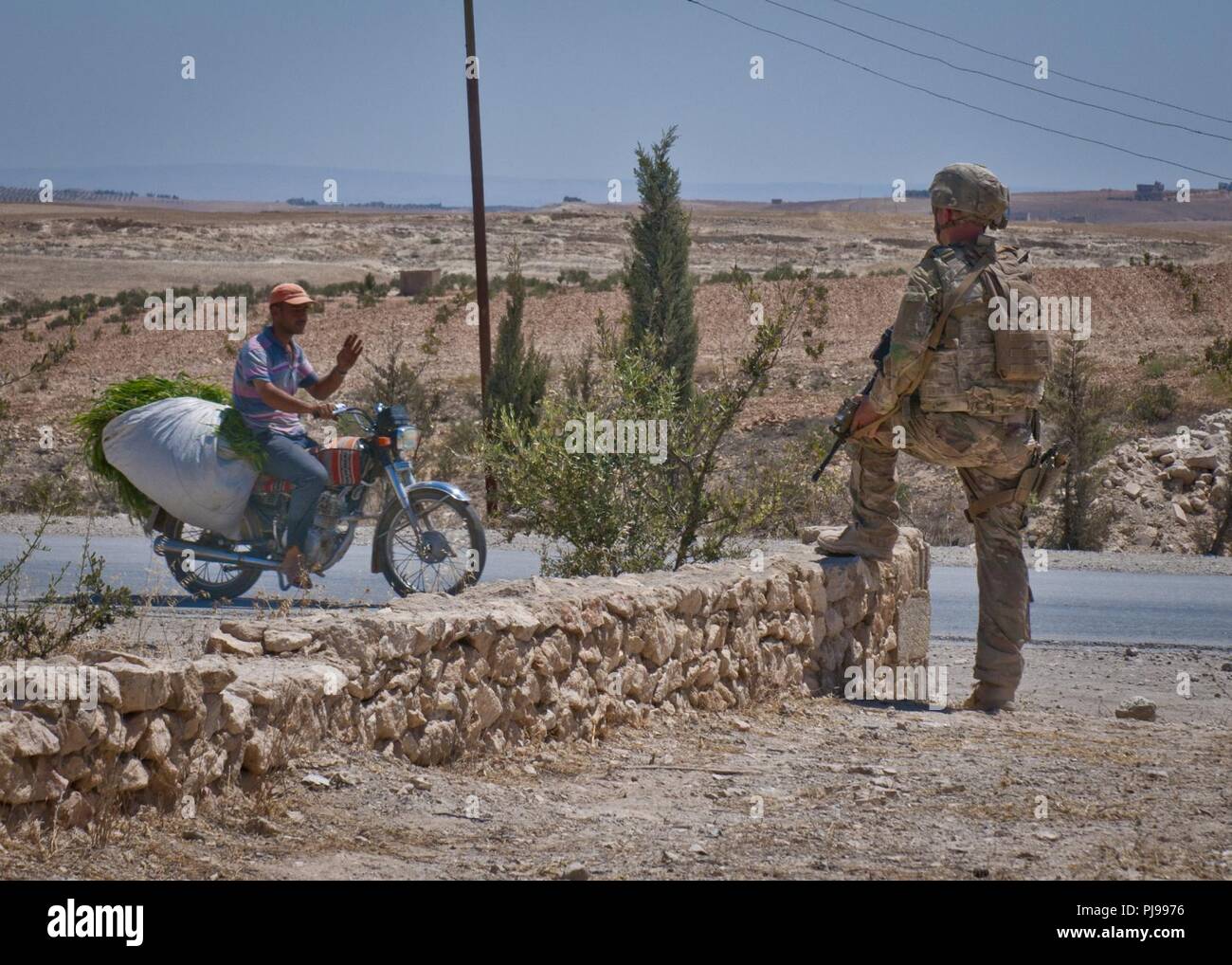 A U.S. Soldier provides security as local traffic passes near a ...