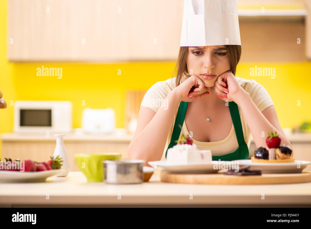 Young cook cooking cakes in the kitchen Stock Photo - Alamy