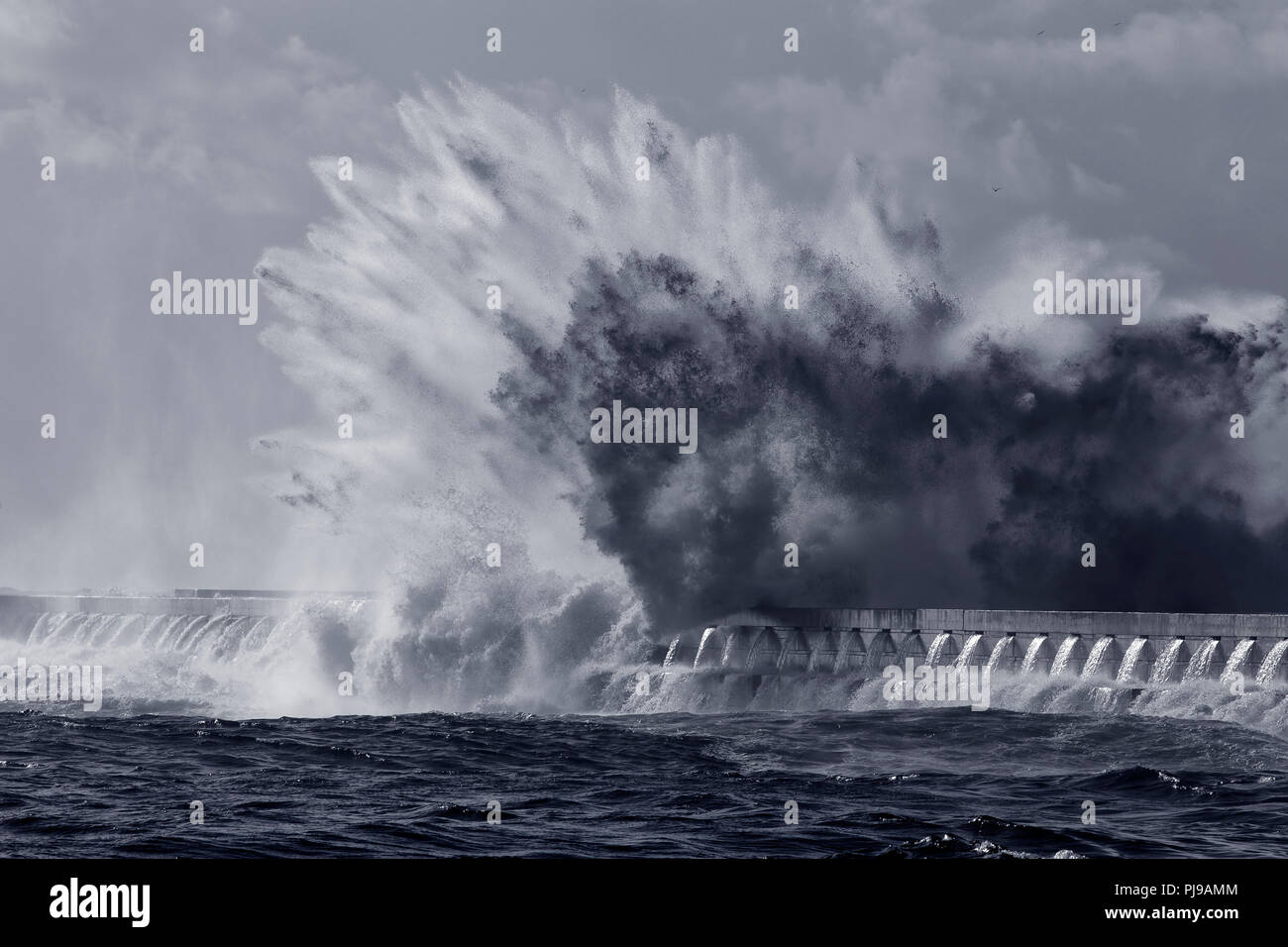 Huge sea wave splash toned blue. New pier of Douro river mouth, Porto ...