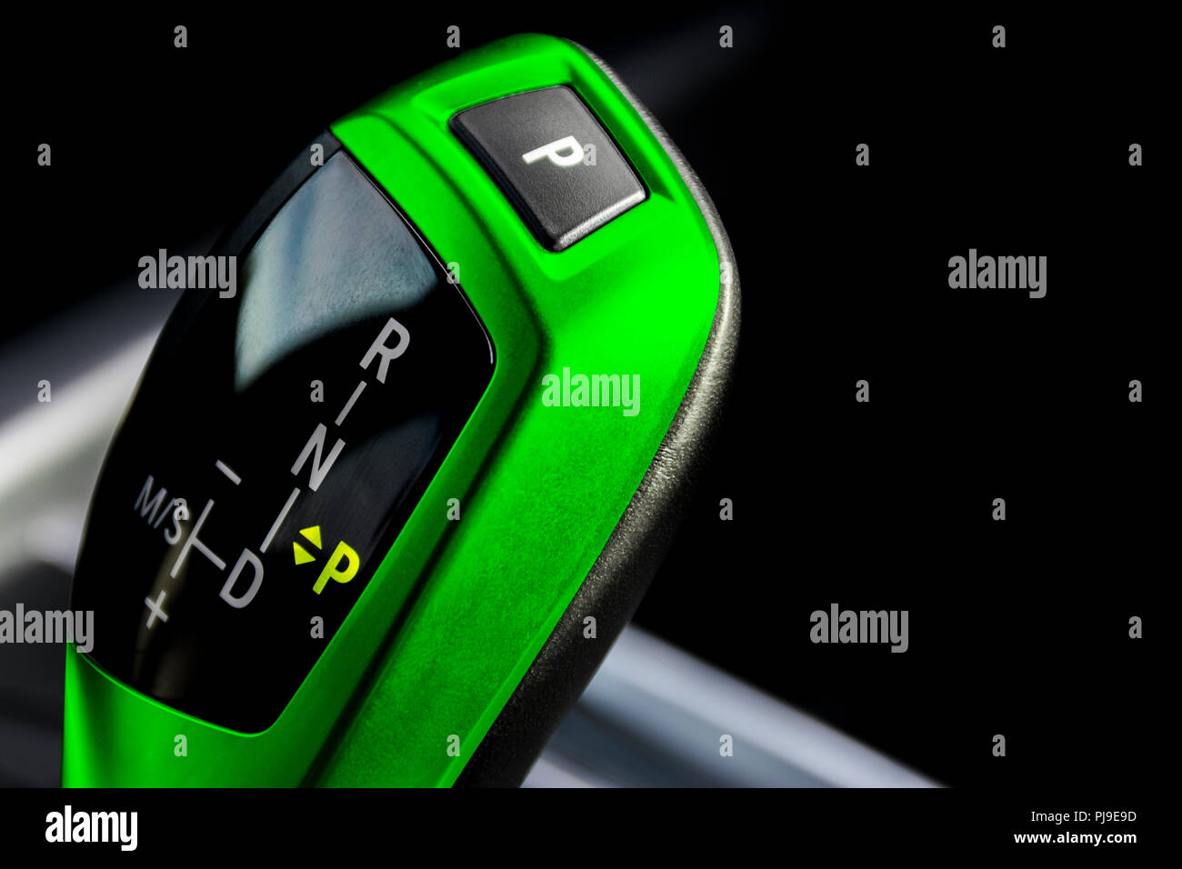 Green Automatic gear stick of a modern car. Modern car interior details. Close up view. Car ...