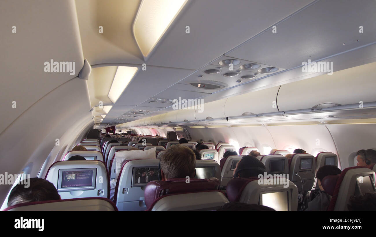 Interior passengers airplane with people on seats. Aircraft cabin with ...