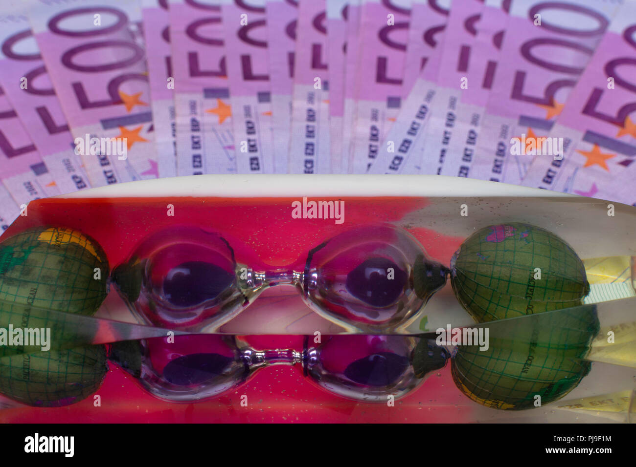 EURO banknotes, color hourglass with world on 500 notes background ...
