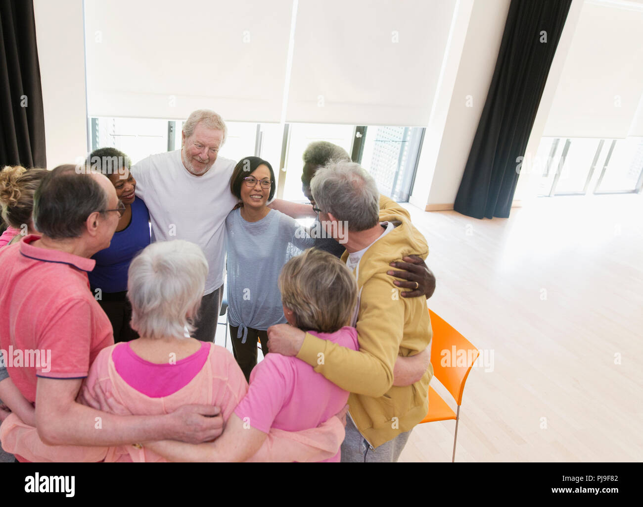 Active seniors hugging in circle Stock Photo - Alamy