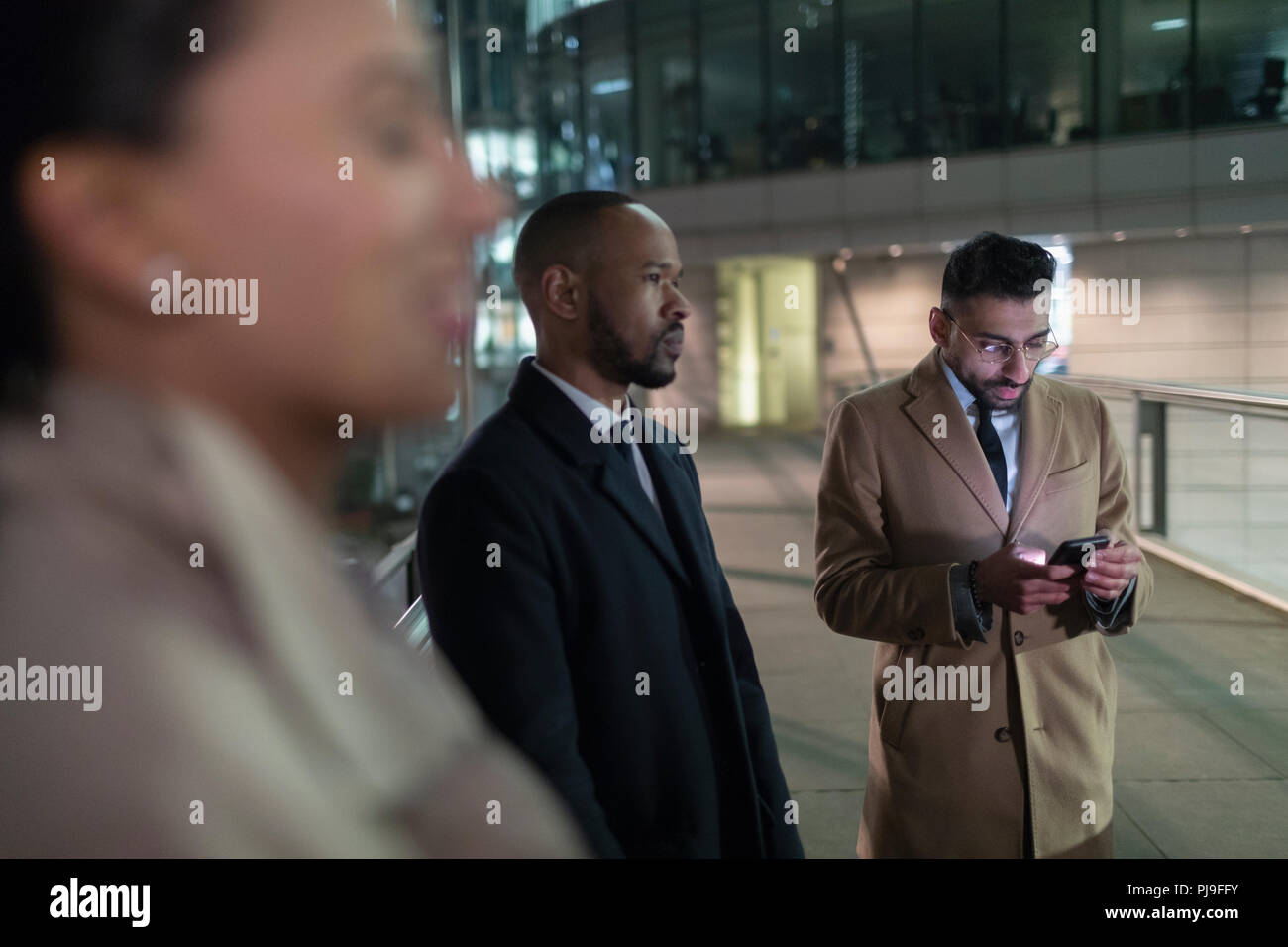 Businessman using smart phone on urban pedestrian bridge at night Stock ...