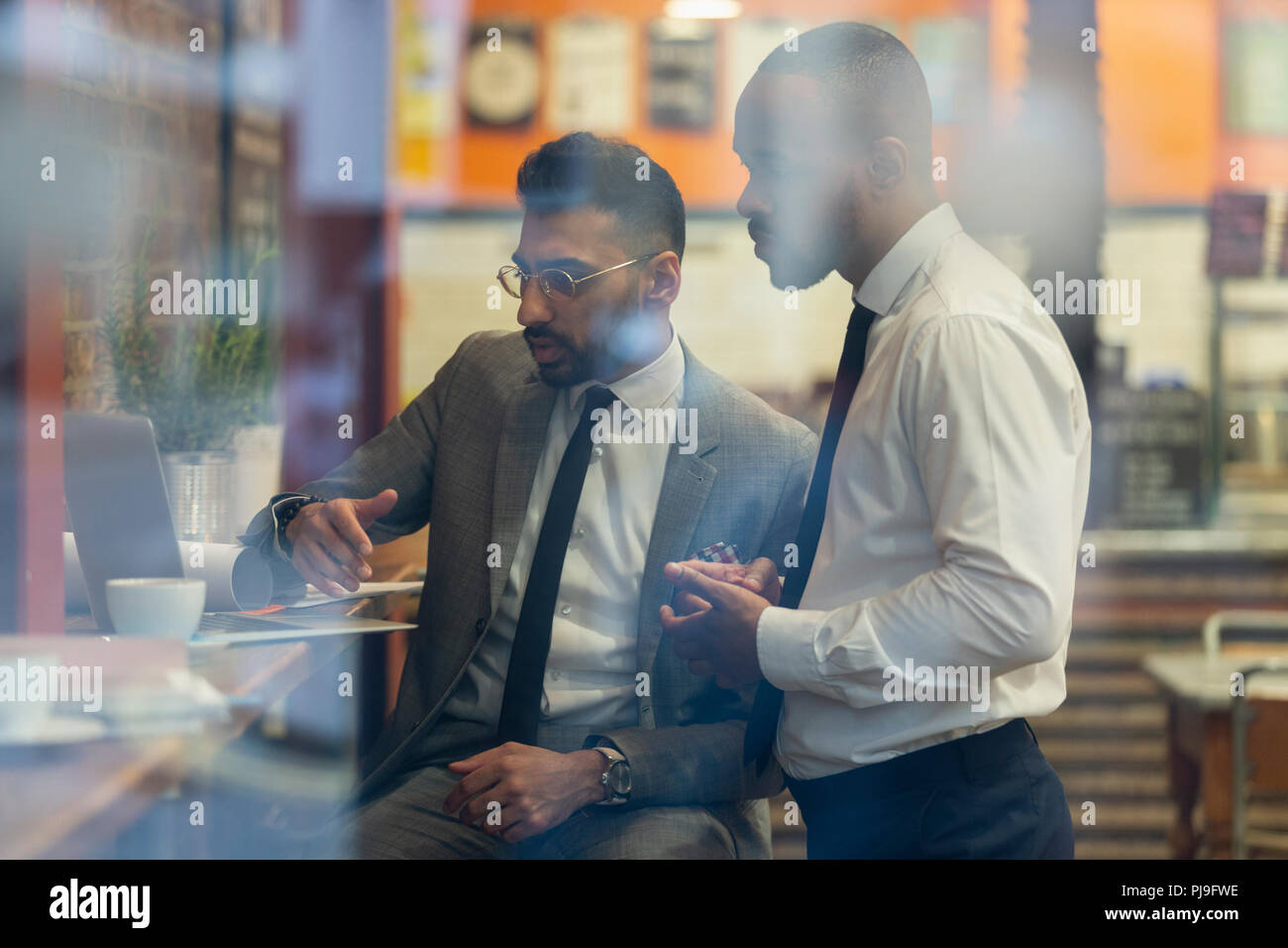 Businessmen working at laptop in cafe Stock Photo - Alamy