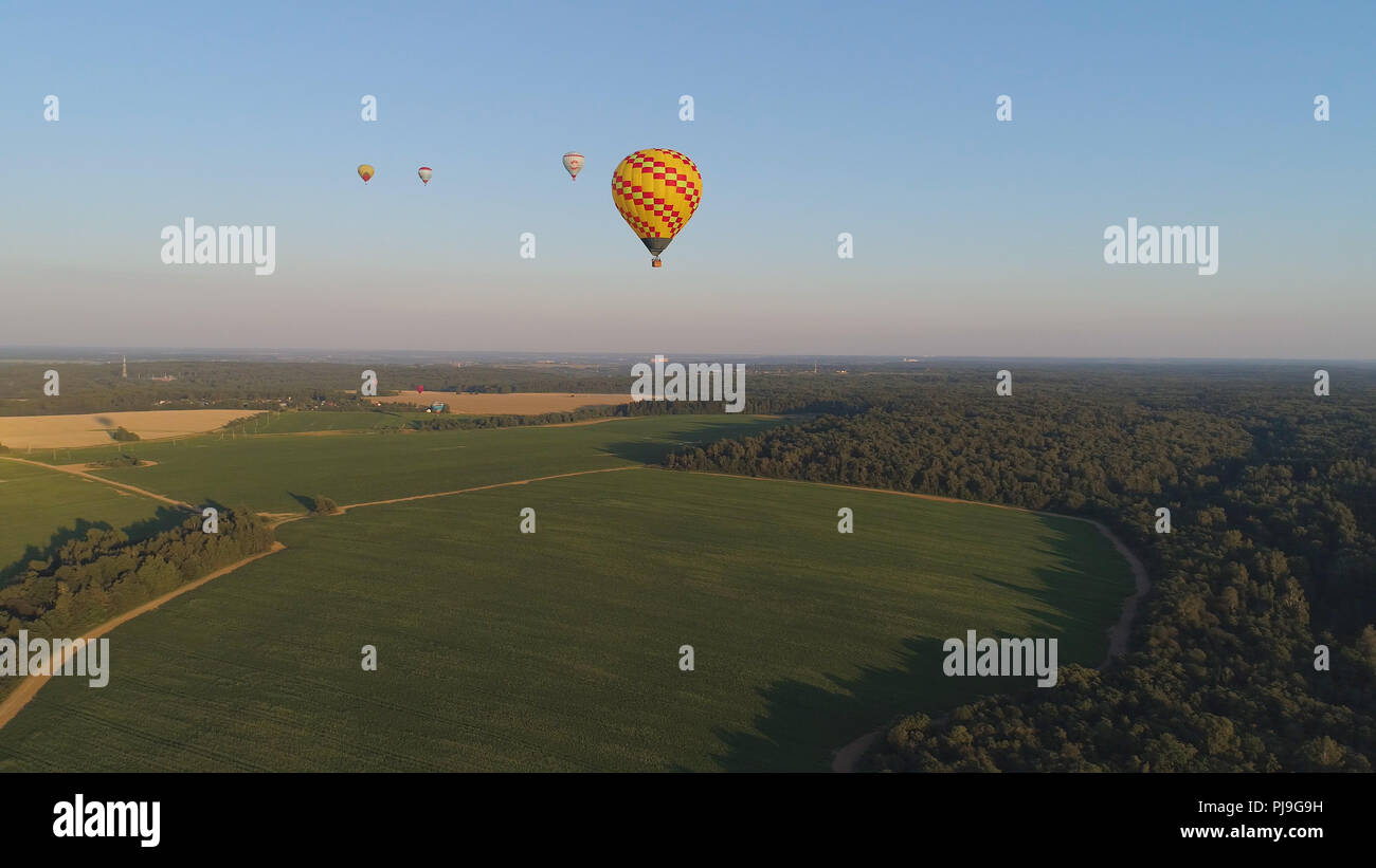 Aerial view Hot air balloons in sky over fields in countryside ...