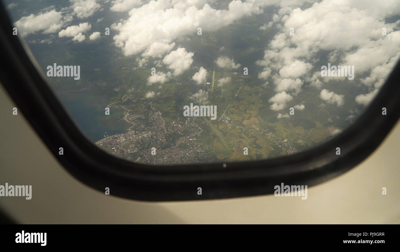 View through an airplane window on the tropical island, ocean, sea, sky ...