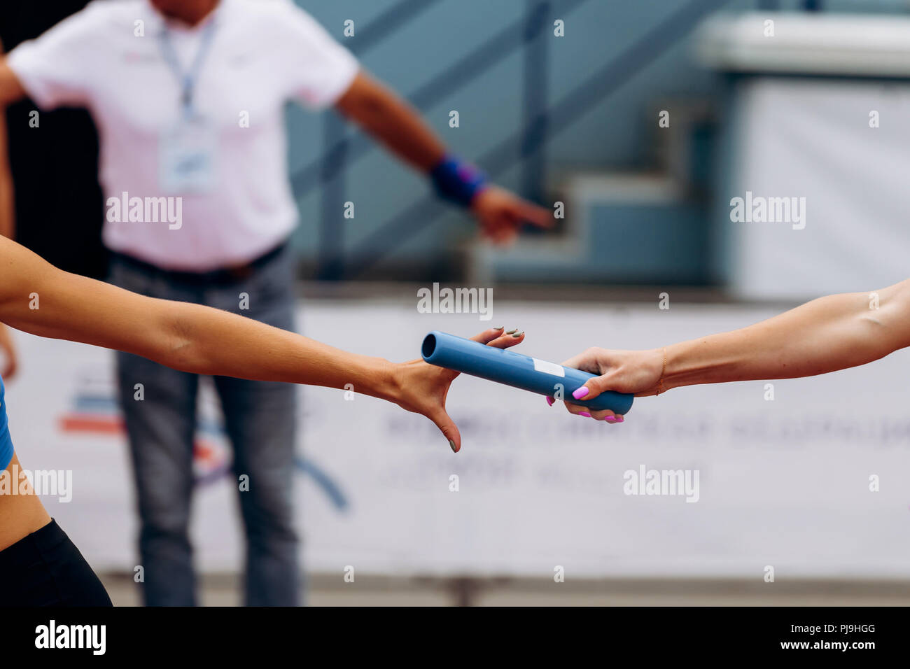 passing of baton from hand to hand women relay race Stock Photo - Alamy
