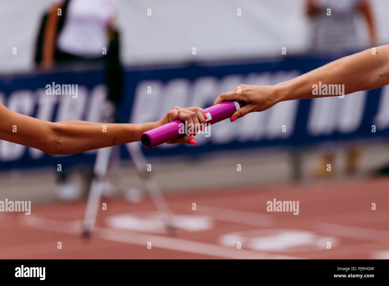 women team relay race passing of baton on stage Stock Photo - Alamy