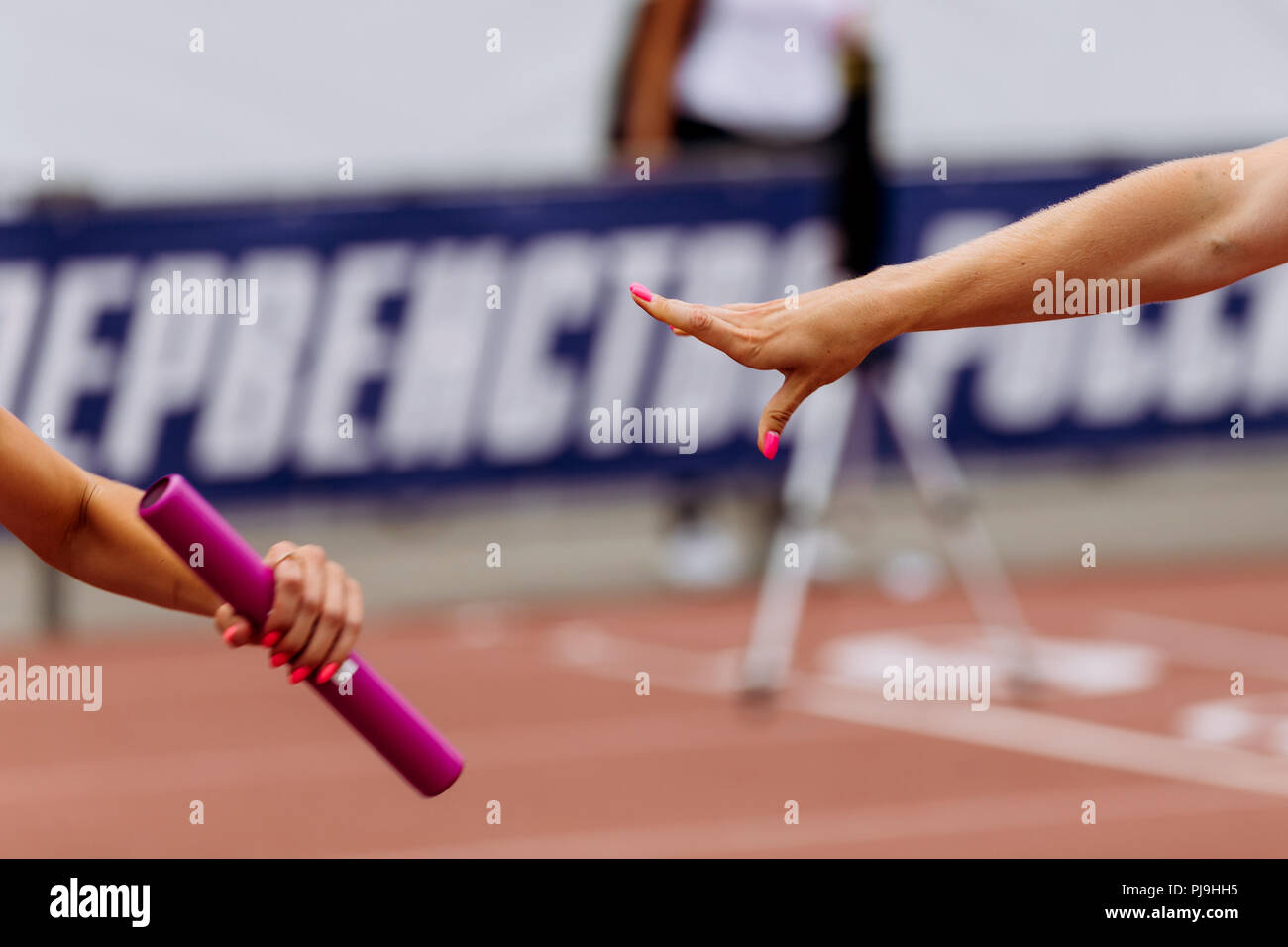 hands women runners passing baton in relay race Stock Photo - Alamy
