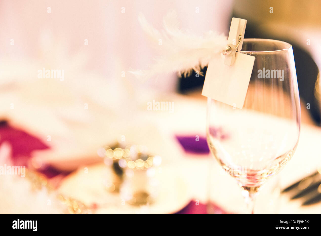 Wine Glass Feather Name Tag on Wedding Table Stock Photo - Alamy