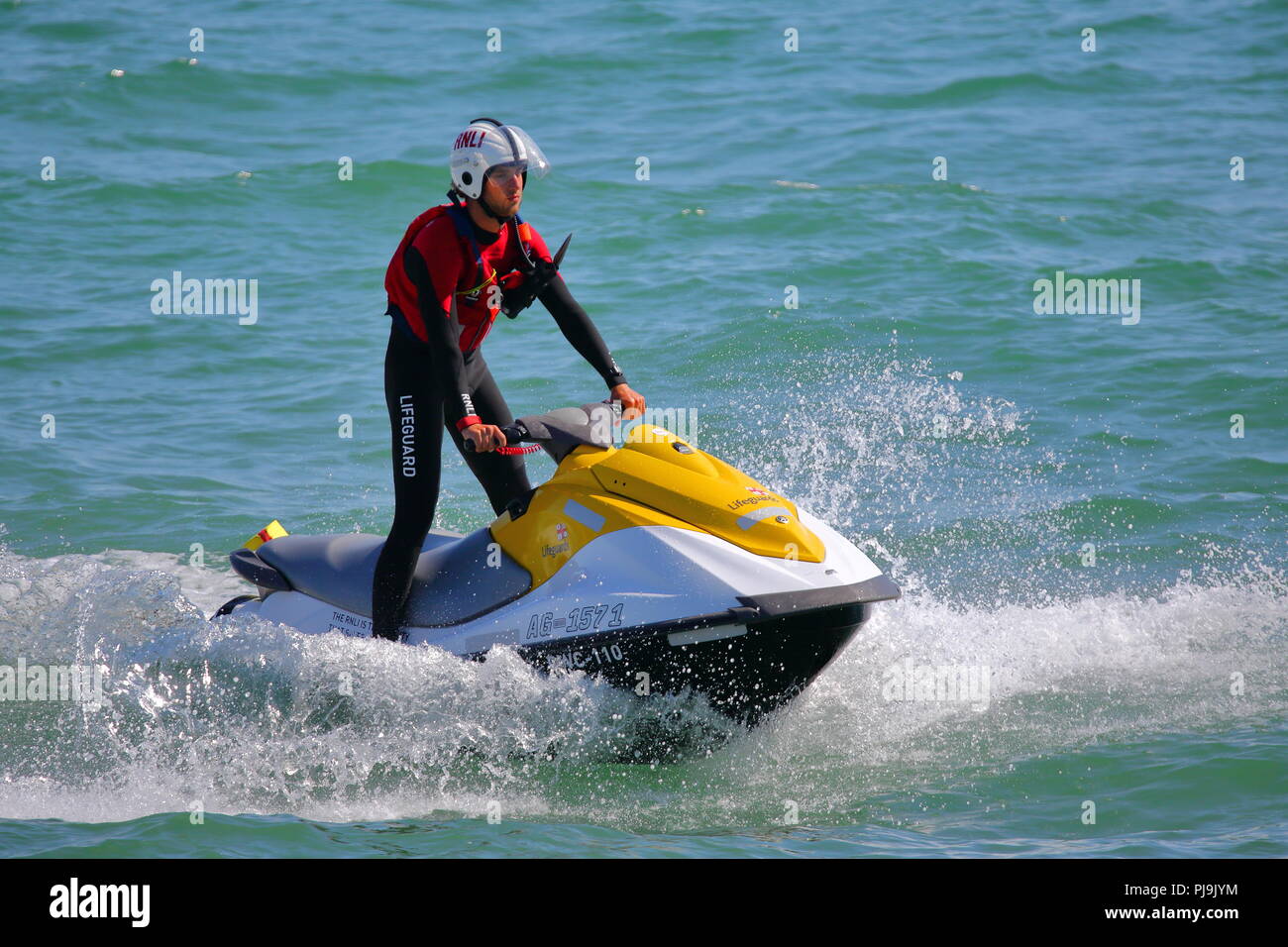 An RNLI Lifeguard patrolling the beach on a jet ski at the Bournemouth ...