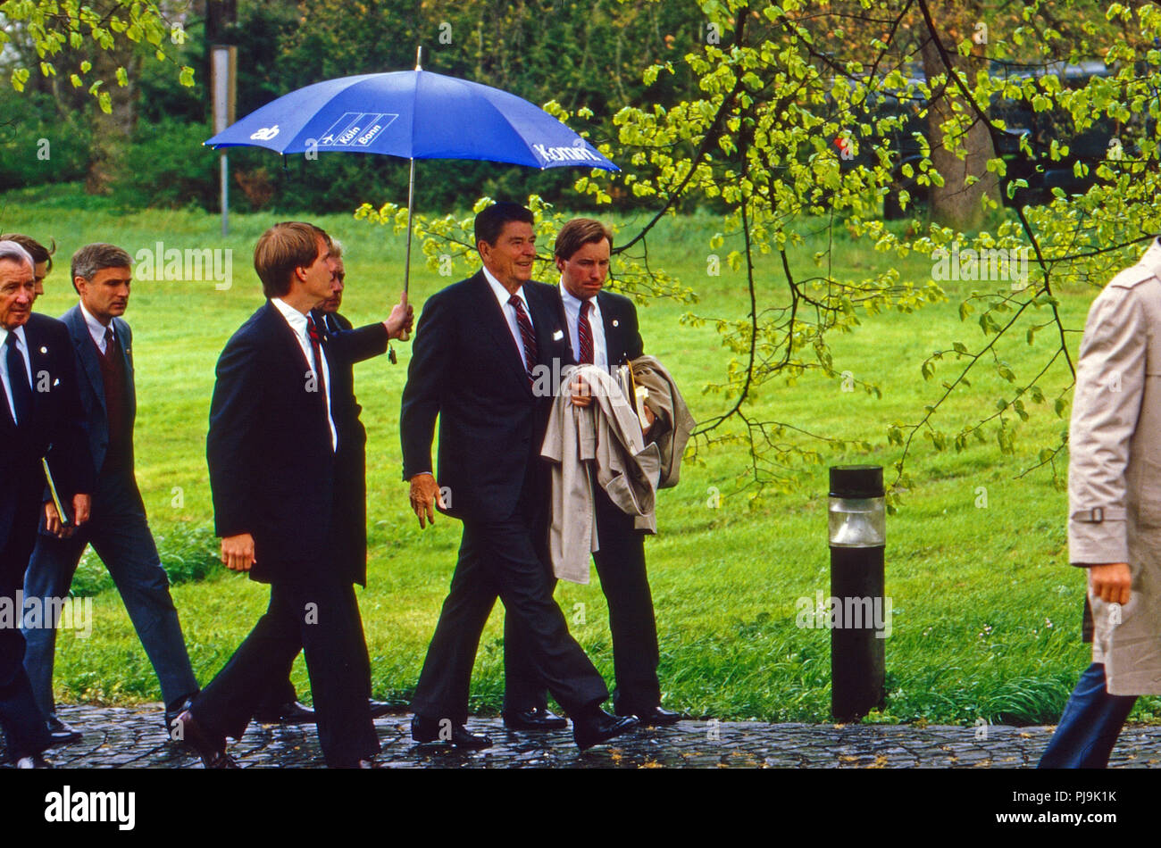 Der amerikanische Präsident Ronald Reagen unter dem Regenschirm beim ...