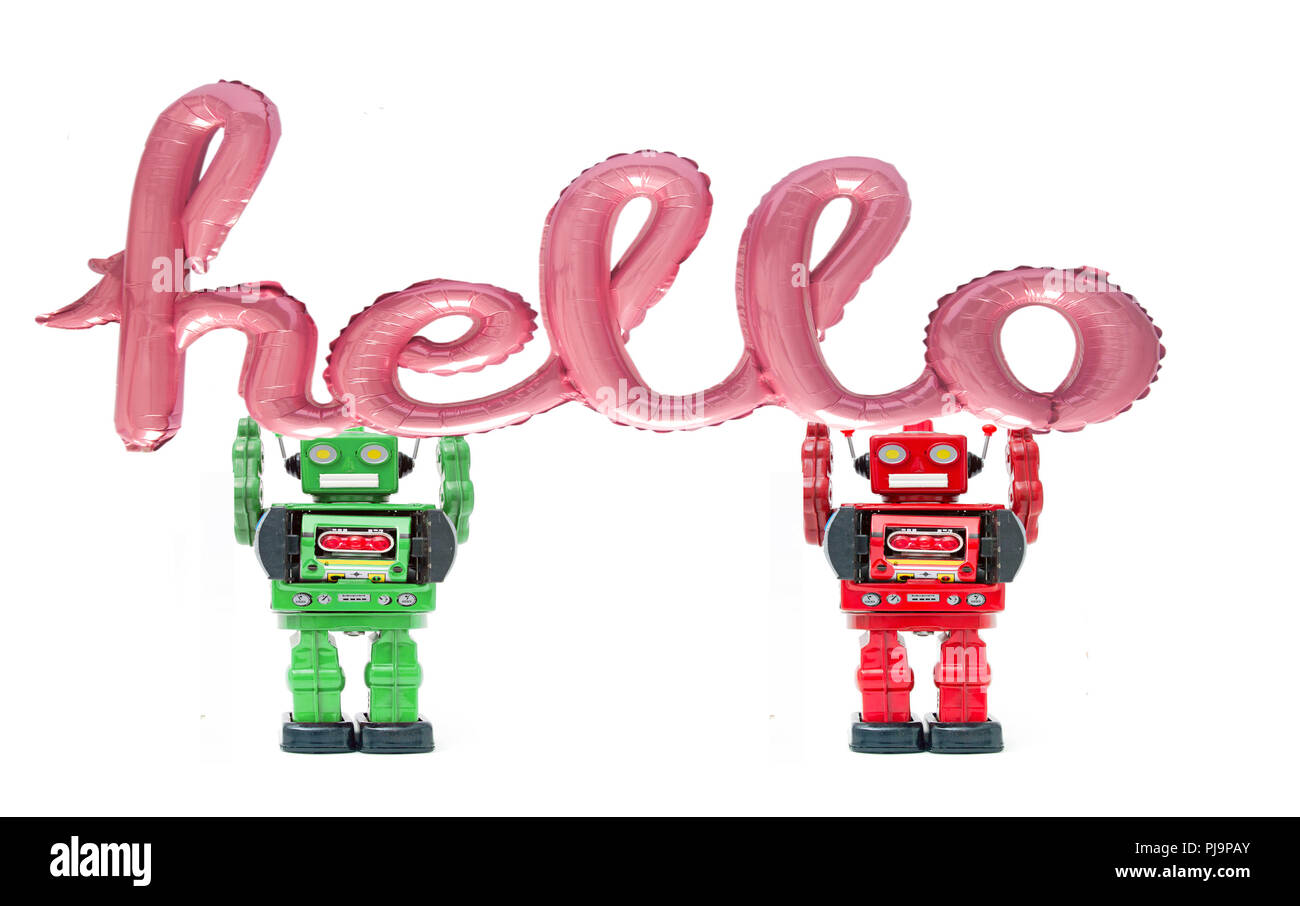 two retro robots hold up the word hello isolated Stock Photo - Alamy