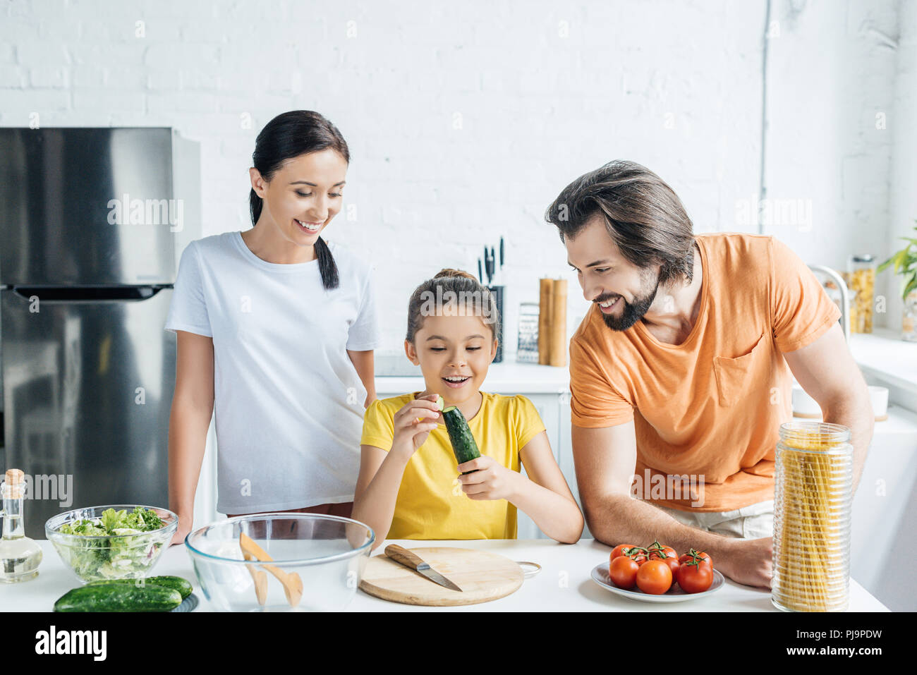 beautiful young family cooking healthy dinner together at kitchen Stock ...