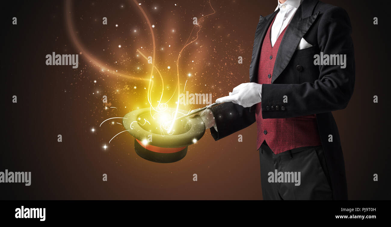 Magician hand conjure with wand light from a black cylinder Stock Photo ...