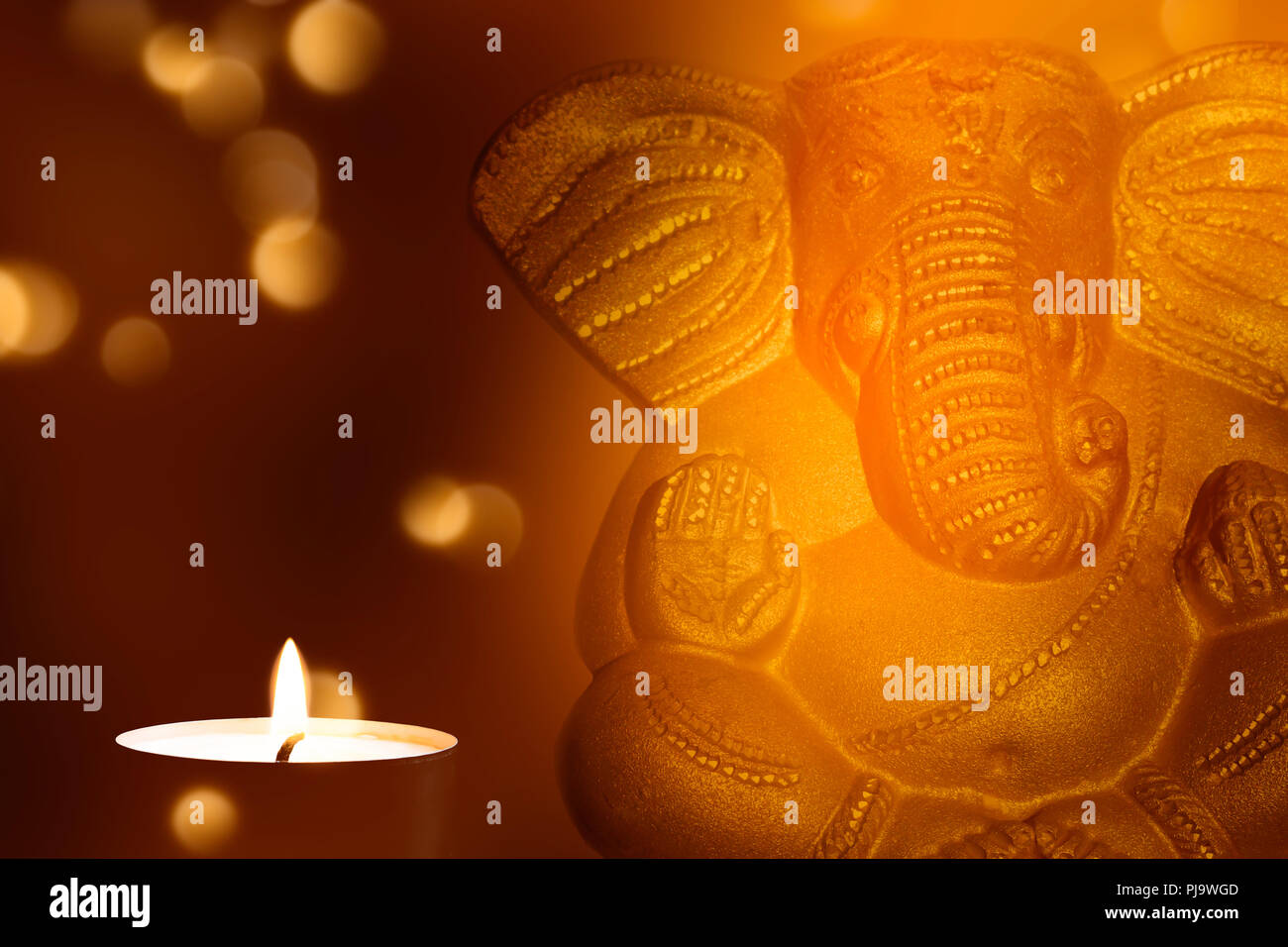 ganesh statue with shiny tea light Stock Photo - Alamy
