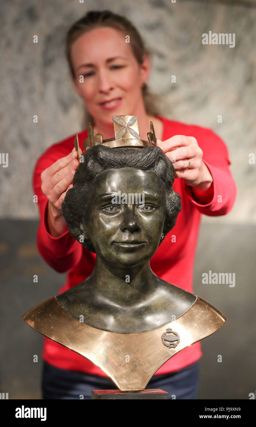 Lindsay Hoadley of Summer Place Auctions, places a crown on a bronze ...