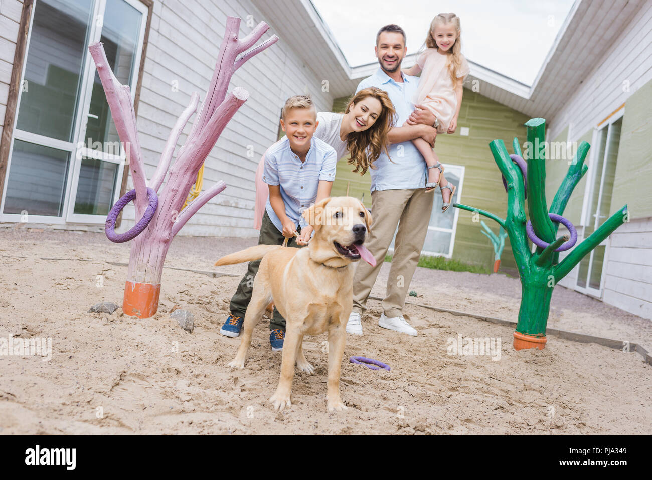 smiling parents and children standing with adopted labrador at animals ...