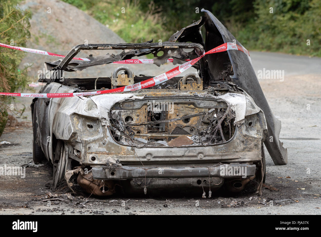 Fire damaged car showing the Fire & Rescue Service Do Not Cross plastic ...