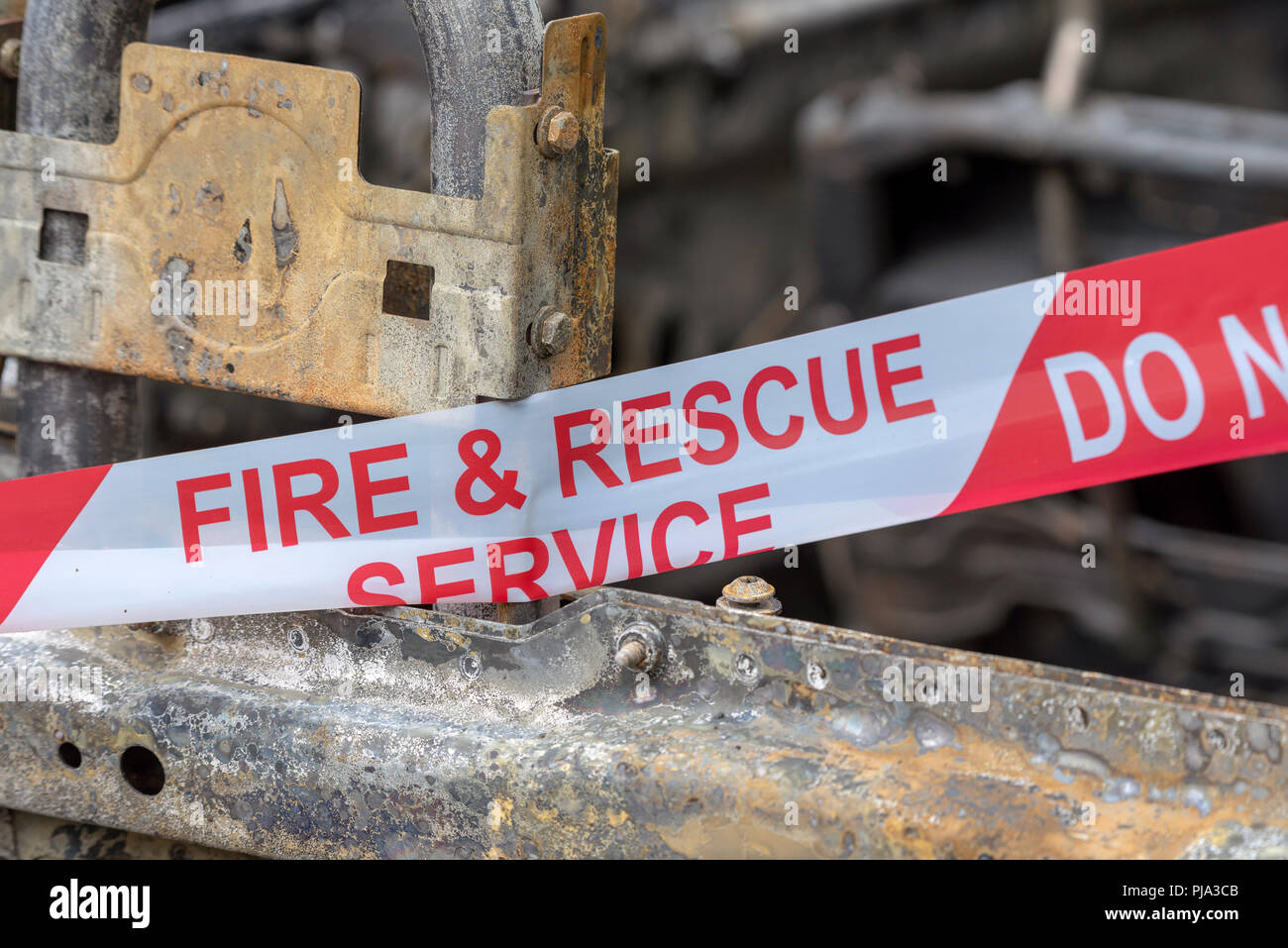 Fire damaged car showing the Fire & Rescue Service Do Not Cross plastic ...