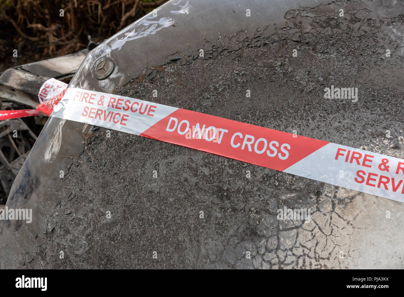 Fire damaged car showing the Fire & Rescue Service Do Not Cross plastic ...