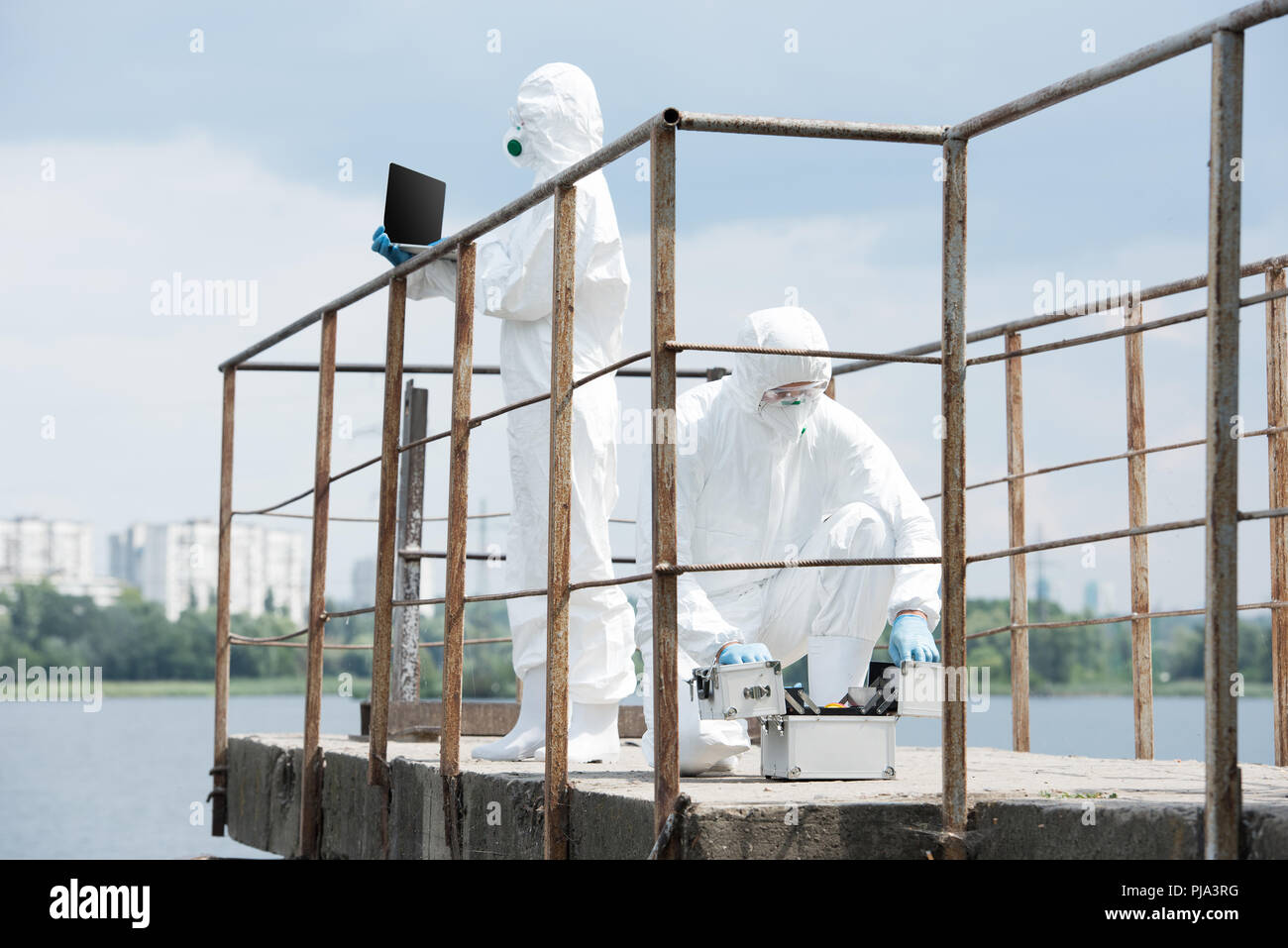 female scientist working with laptop while her colleague opening ...