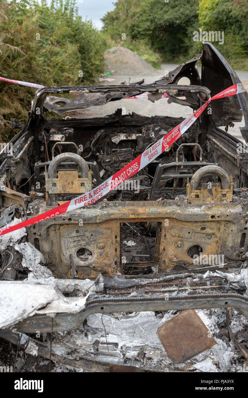 Fire damaged car showing the Fire & Rescue Service Do Not Cross plastic ...