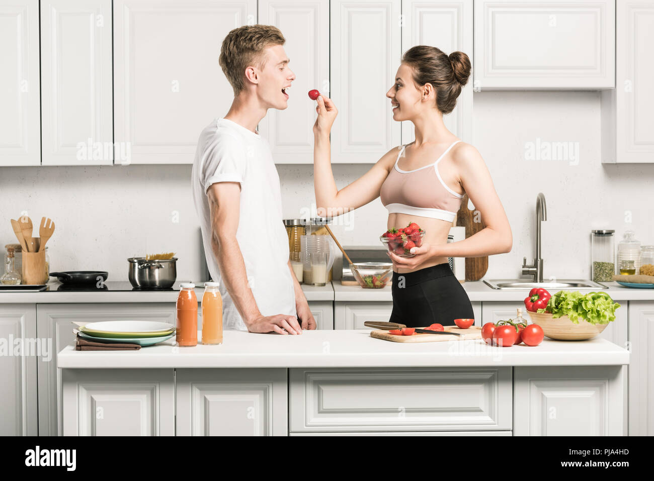 Young man feeding girlfriend strawberry hi-res stock photography and ...