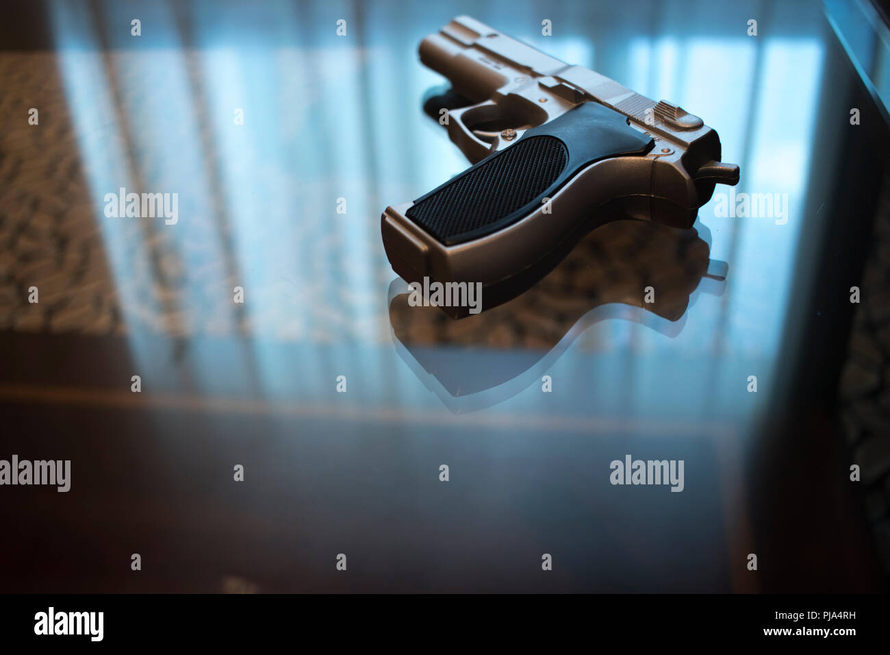 Automatic pistol gun on glass table in bedroom in luxury hotel in ...