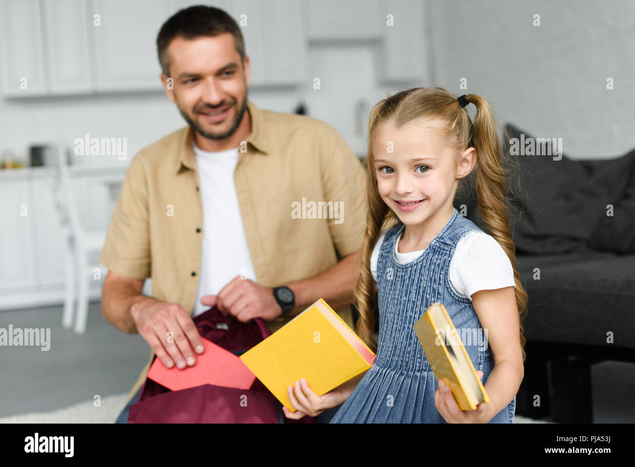 selective focus of smiling father helping little daughter packing ... selective focus of smiling father helping little daughter packing ...