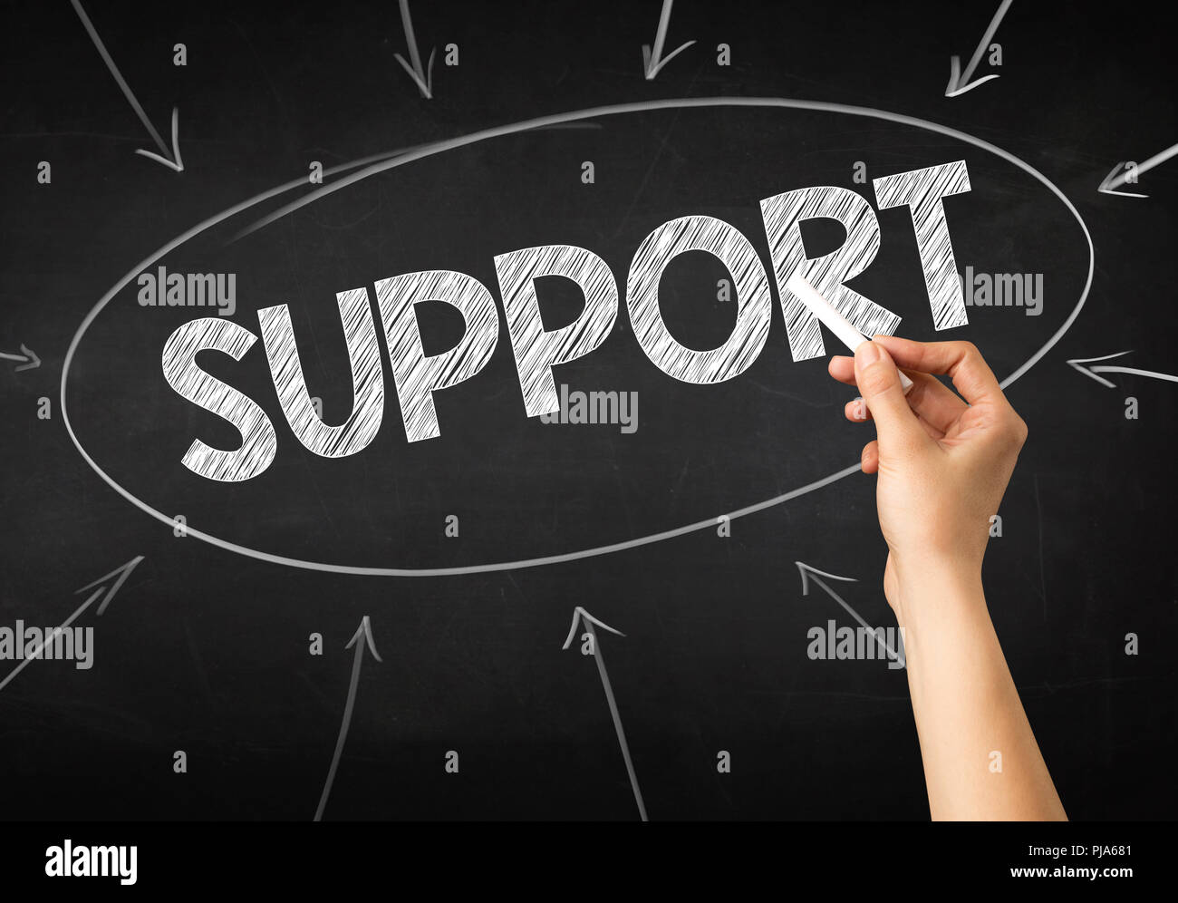 Female hand holding white chalk in front of a blackboard with support ...