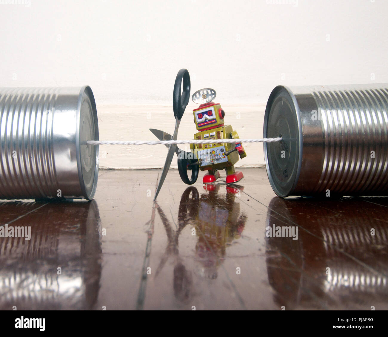 concept phone line being cut of with retro robots on a wooden floor ...