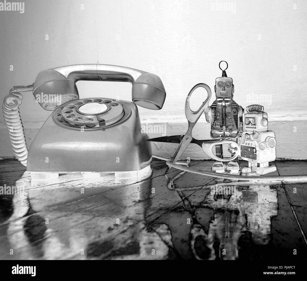 concept phone line being cut of with retro robots on a wooden floor ...