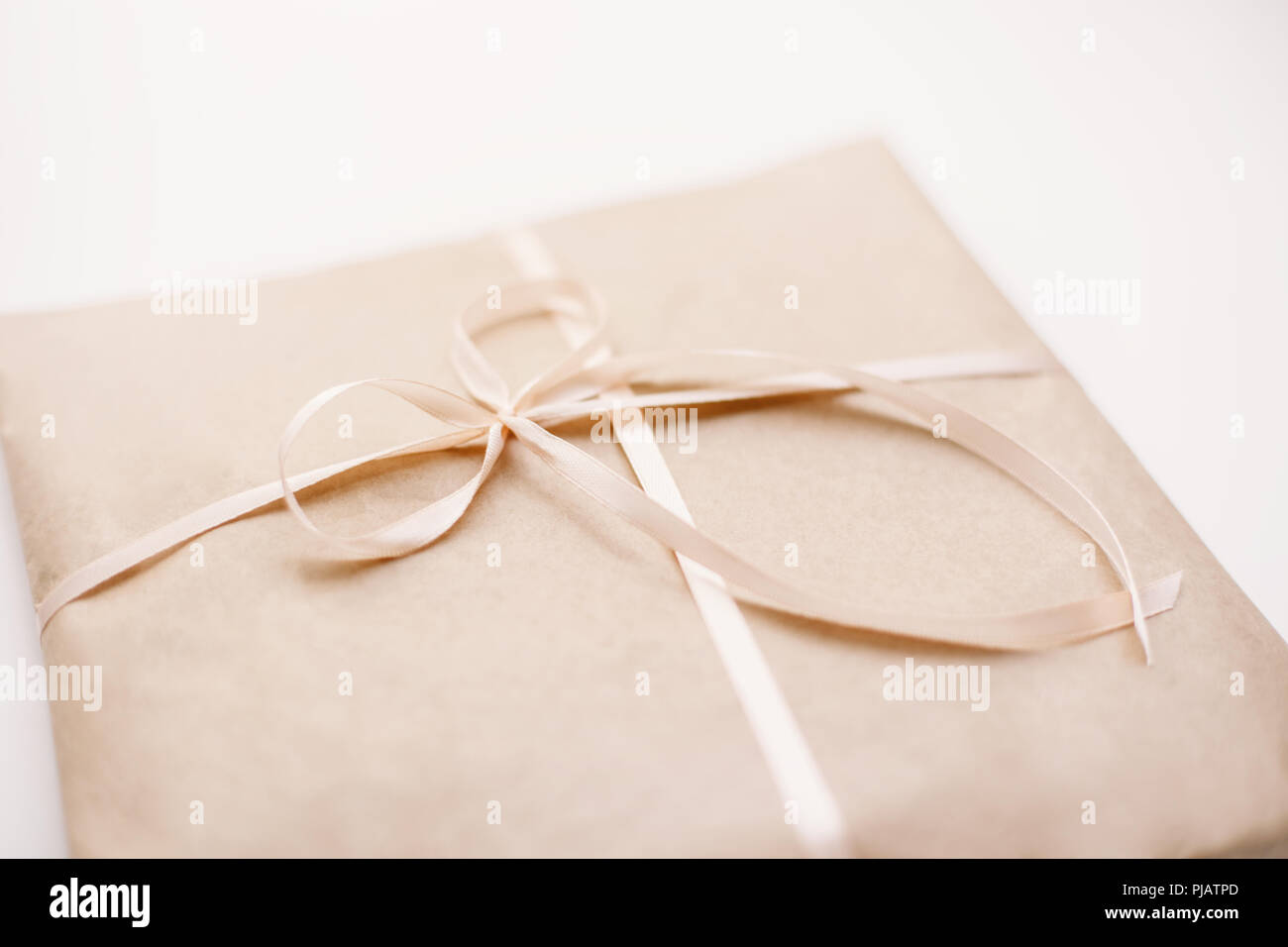 Cardboard carton package wrapped with light brown paper and tied with ...