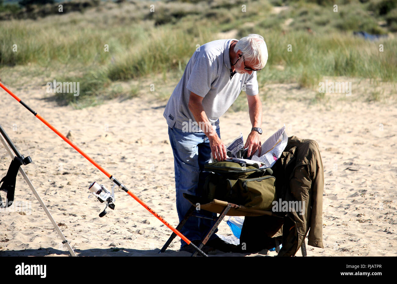 Purbeck, Dorset, UK - Jun 02 2018: Sea angler checking his bait or ...