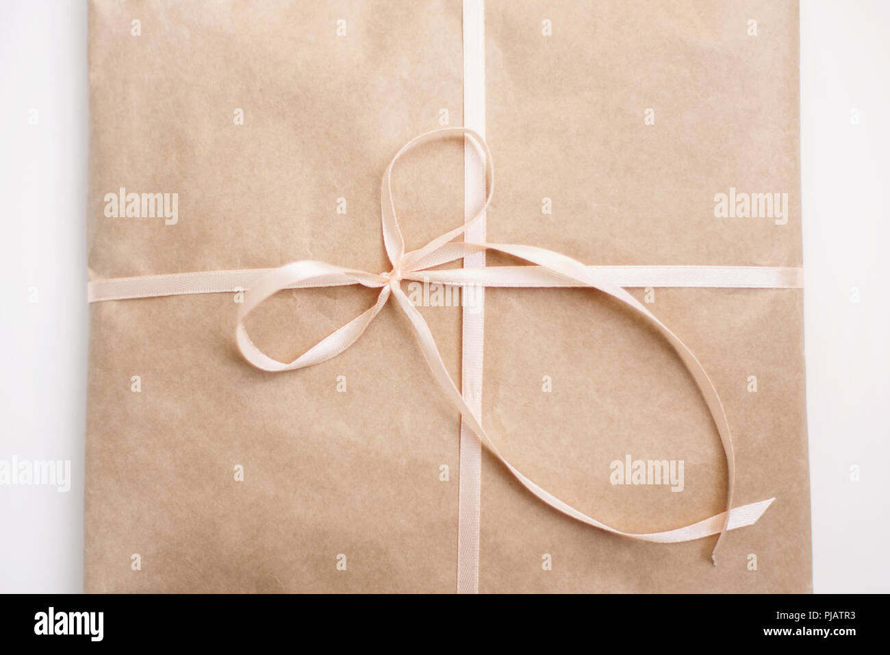 Cardboard carton package wrapped with light brown paper and tied with ...