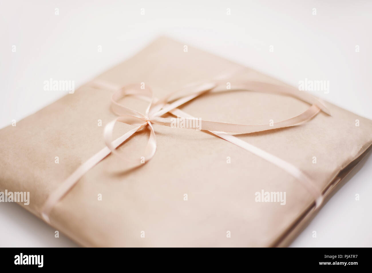 Cardboard carton package wrapped with light brown paper and tied with ...