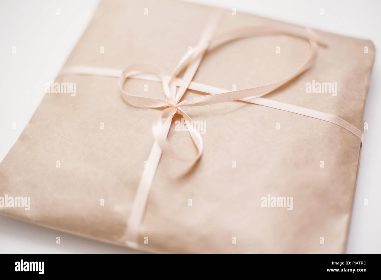 Cardboard carton package wrapped with light brown paper and tied with ...