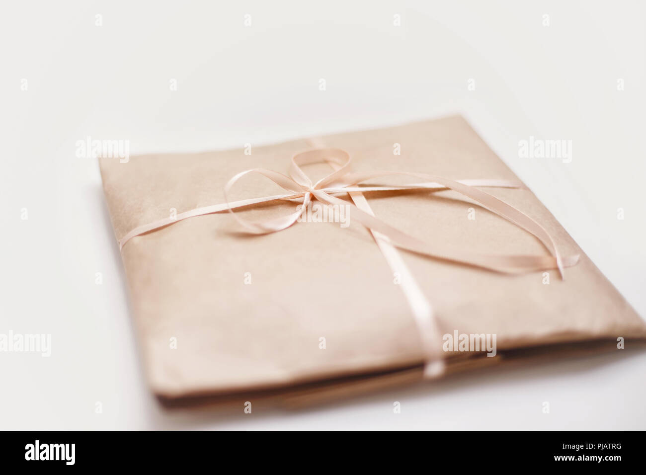 Cardboard carton package wrapped with light brown paper and tied with ...