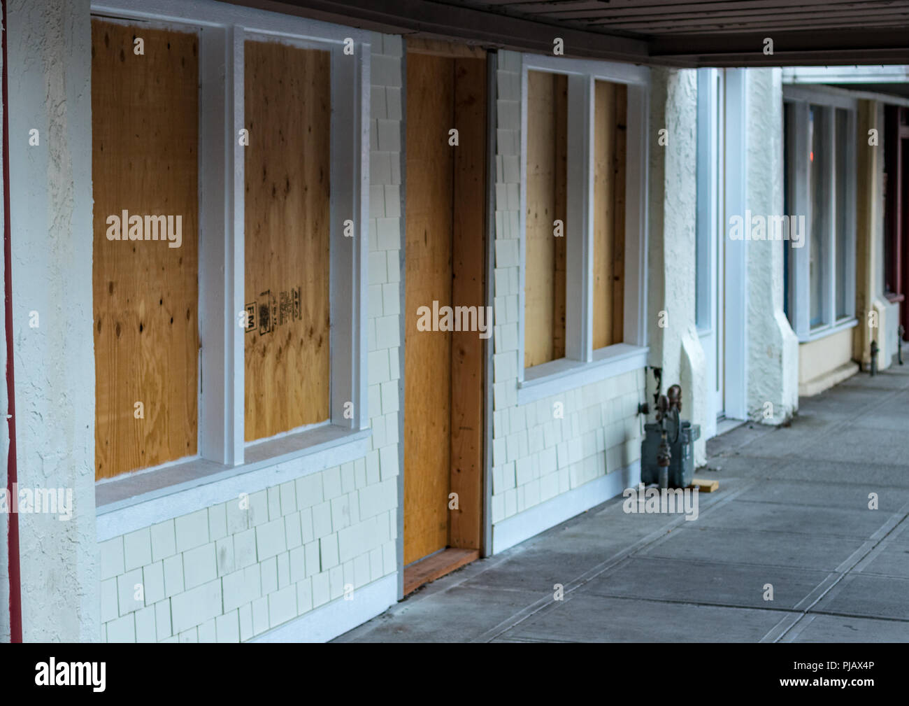 Retail storefront closed and boarded up with plywood Stock Photo - Alamy