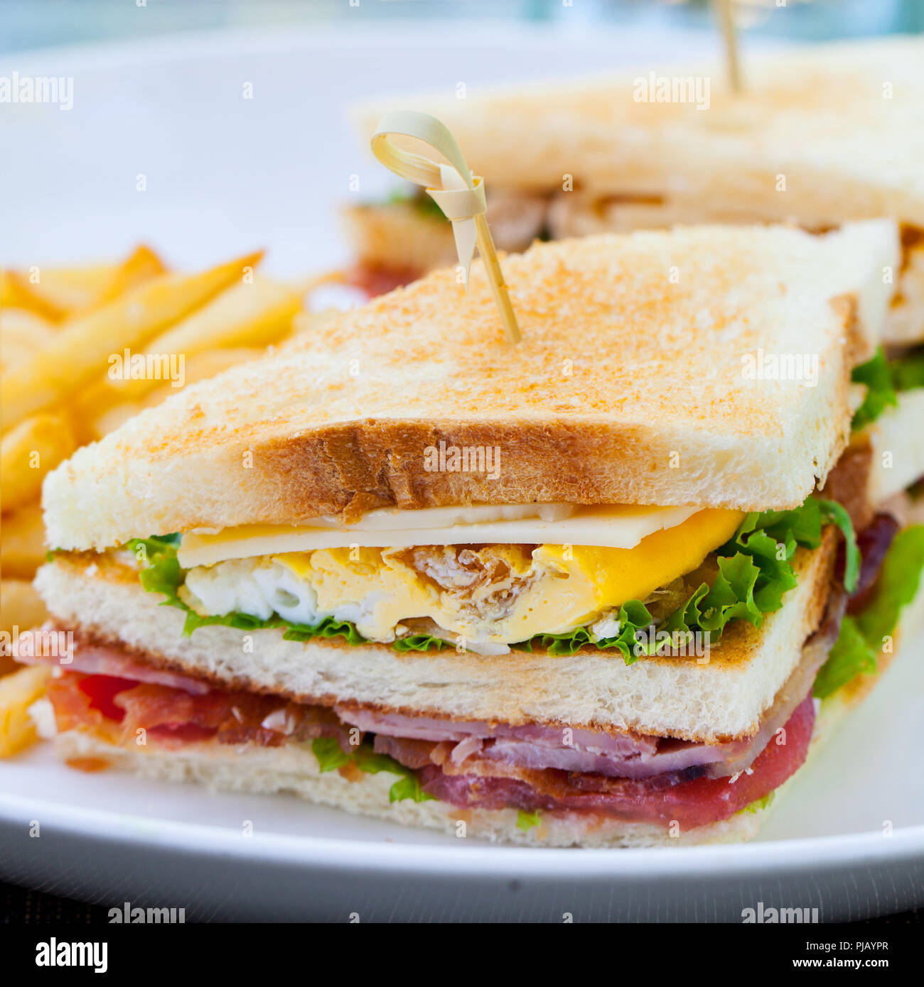Club sandwich with french fries on a white plate. Summer outdoor ...
