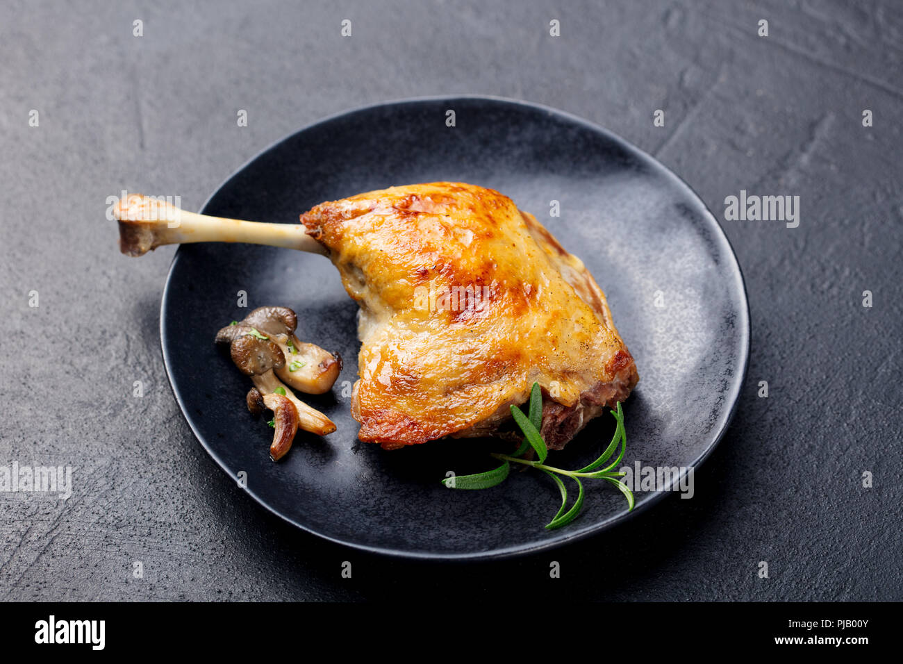 Duck legs confit with mushroom sauce . Restaurant serving. Close up ...