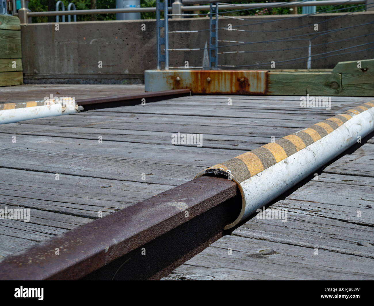 Rusty railroad track on wooden dock next to barrier Stock Photo - Alamy