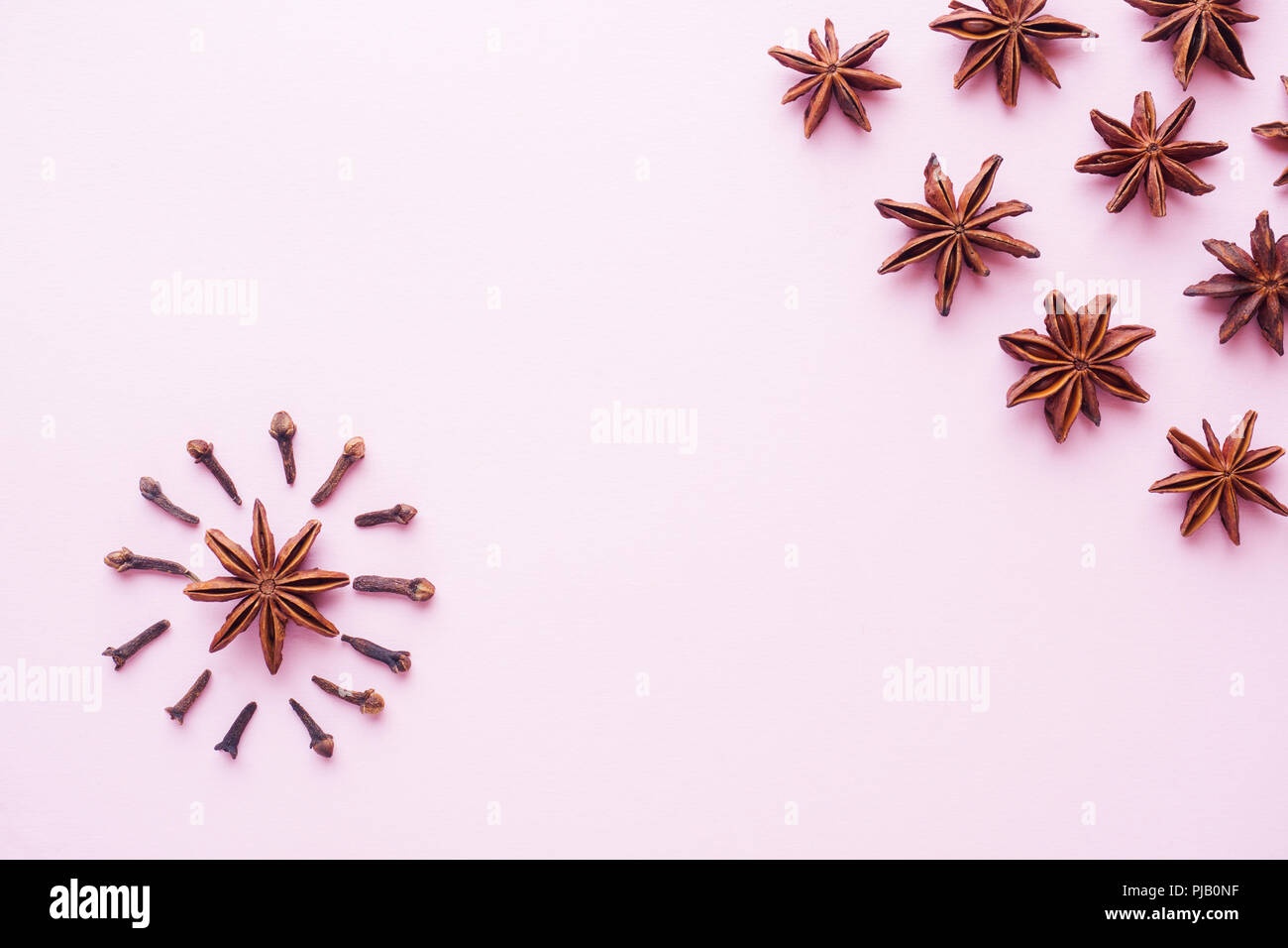 Composition of star anise and cloves on pink background. Abstract flat ...