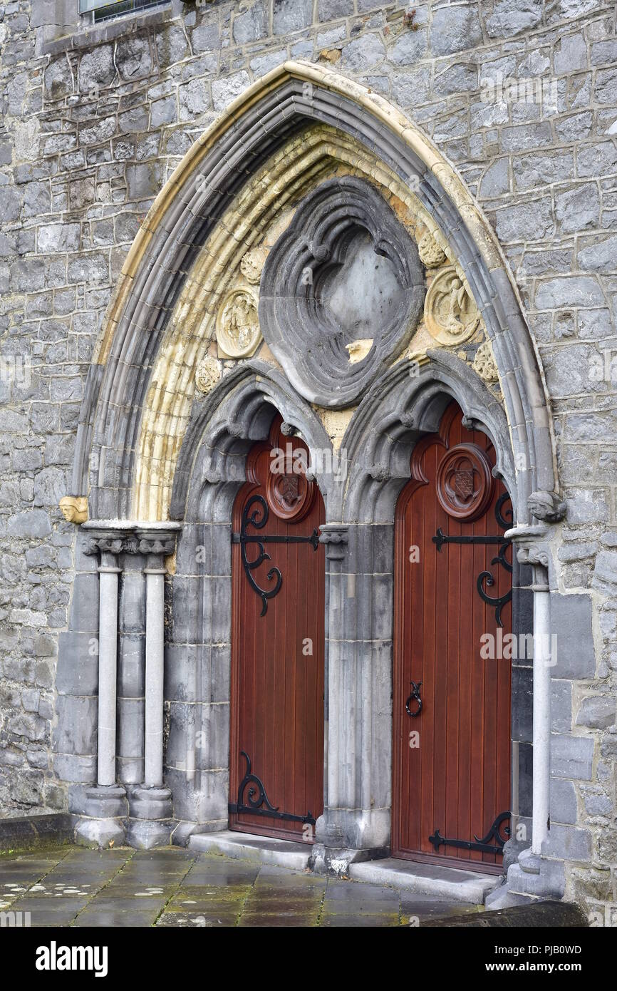 Portrait view of arched dual gate with wooden doors on metal hinges on ...