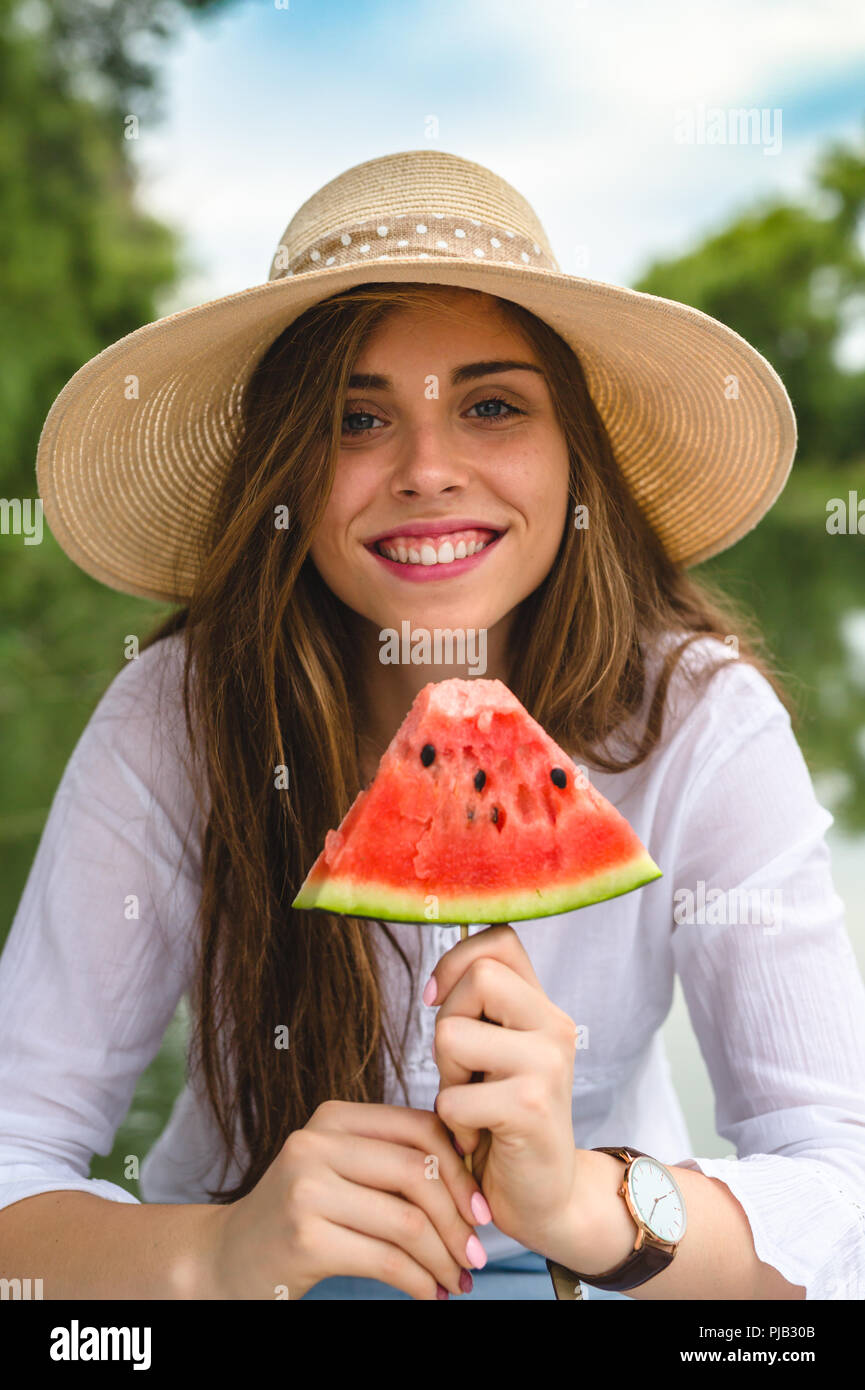 young beautiful woman eating watermelon by the river Stock Photo - Alamy