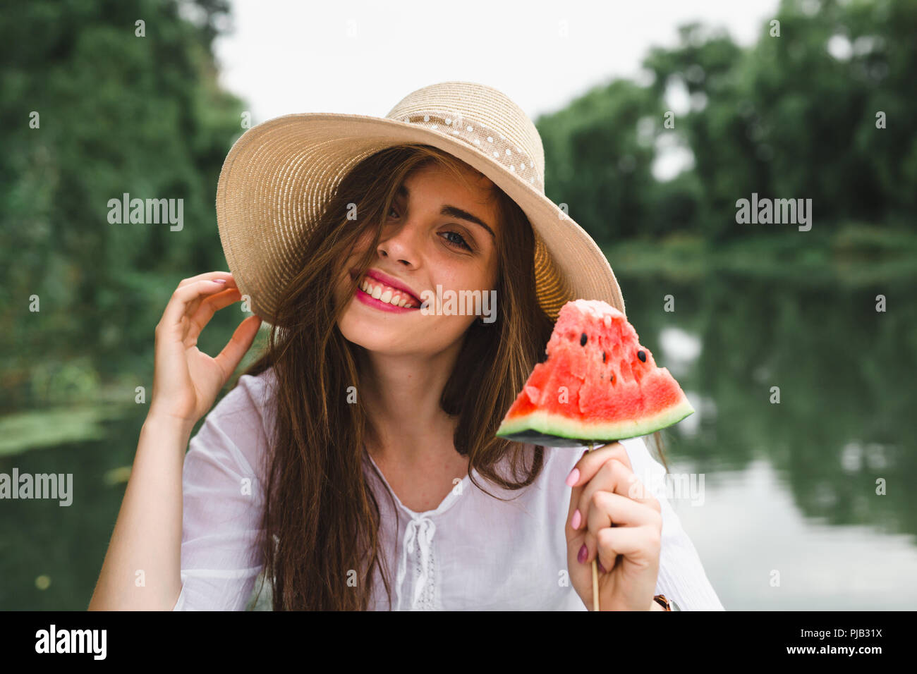 woman eating watermelon on the river dock Stock Photo - Alamy