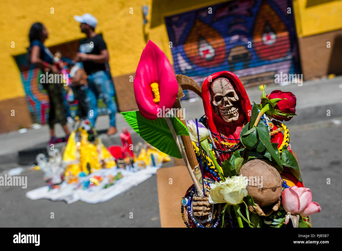 A statue of Santa Muerte (Holy Death), holding fresh flowers, is seen ...