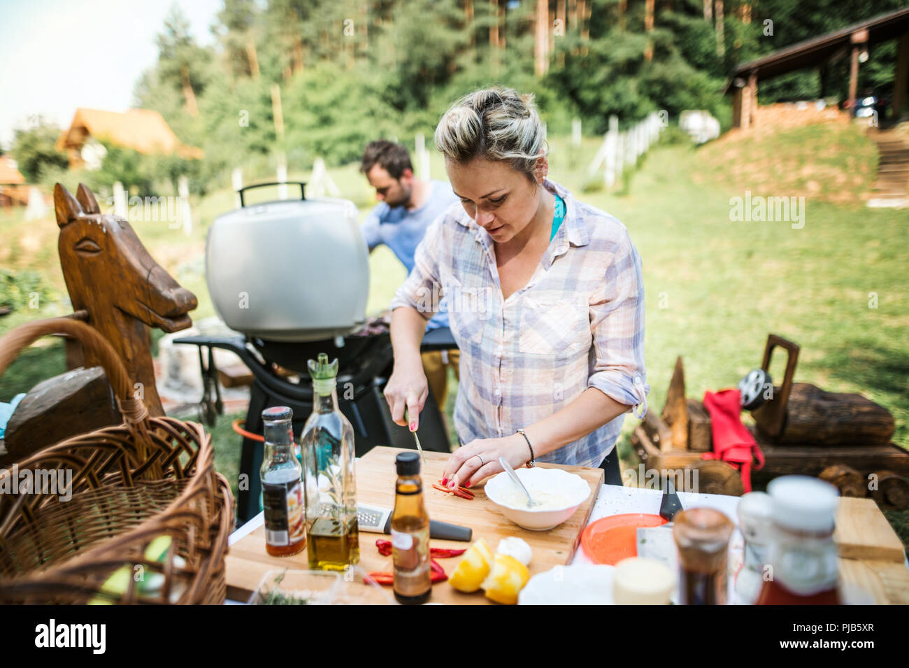 A couple preparing food on a barbecue grill in the backyard Stock Photo ...